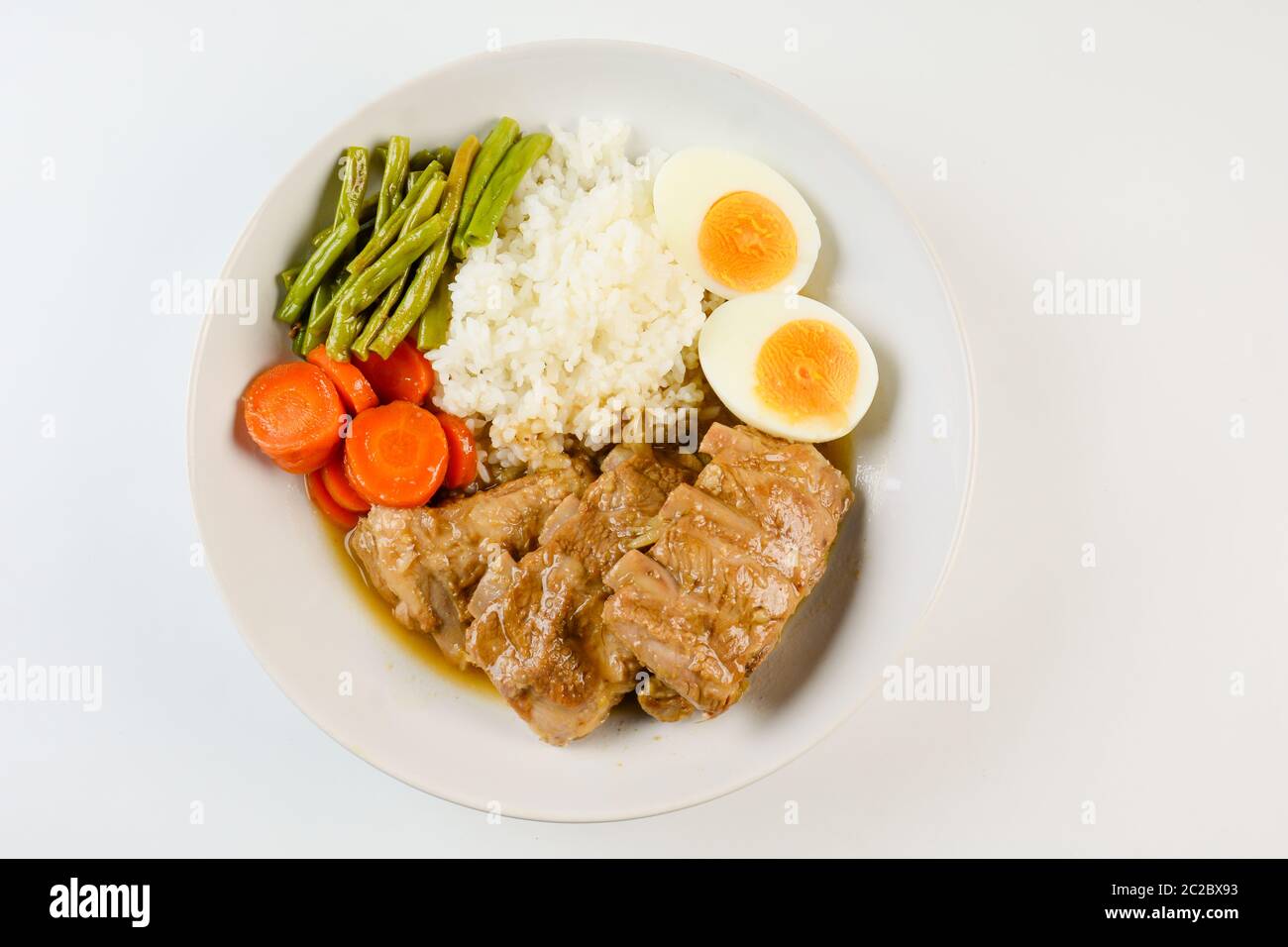 Baked pork ribs with rice, boiled egg and vegetable Stock Photo - Alamy