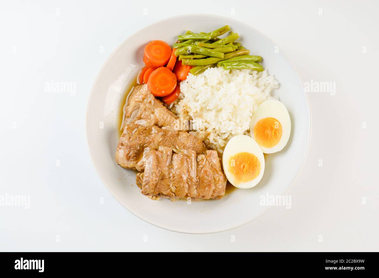 Baked pork ribs with rice, boiled egg and vegetable Stock Photo - Alamy