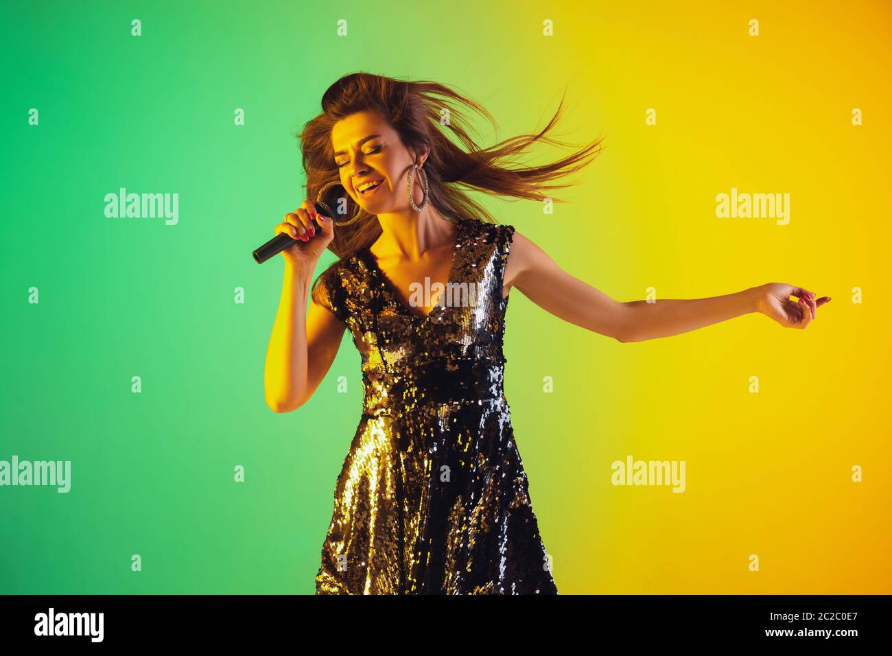 Caucasian female singer portrait isolated on gradient studio background ...