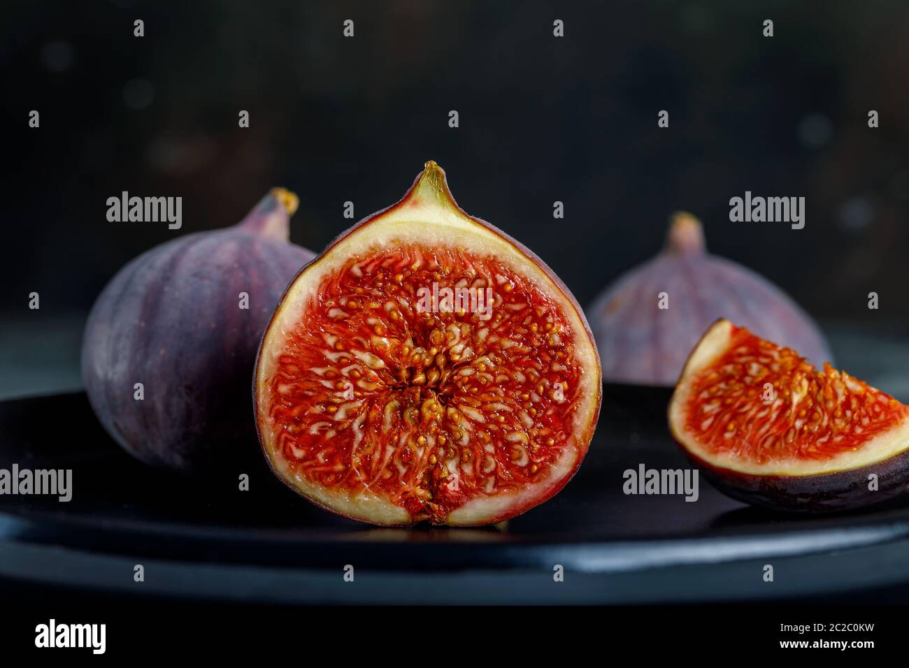 Tropical fig fruit, fresh in half section on the background of whole ...