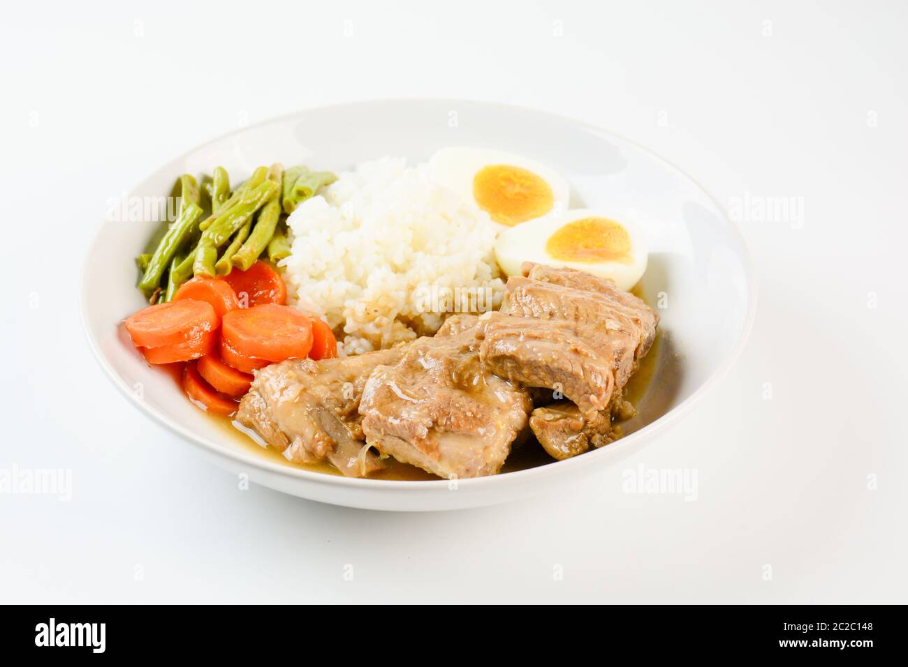 Baked pork ribs with rice, boiled egg and vegetable Stock Photo - Alamy