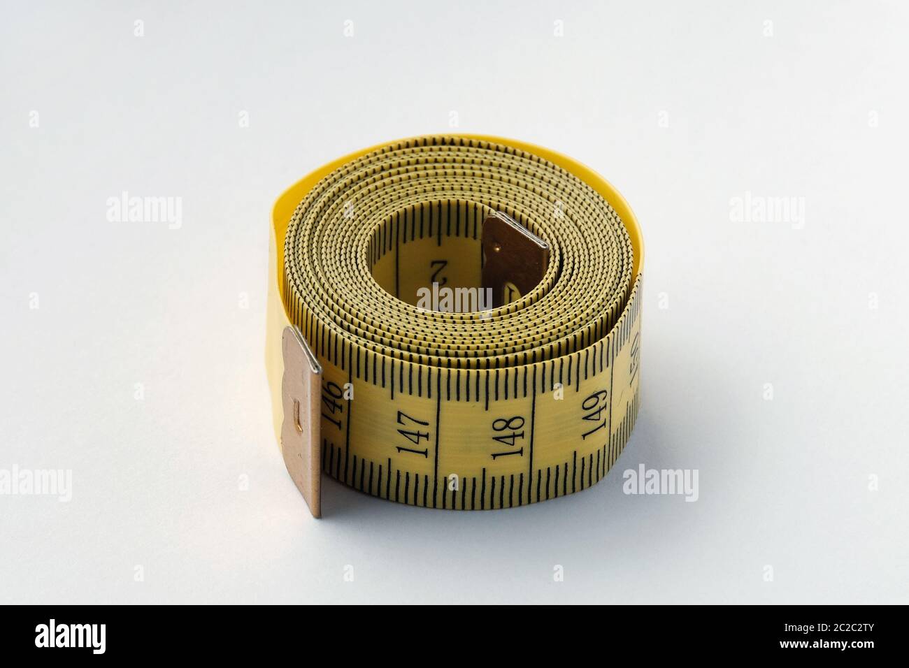 Yellow tape measure on rolled up on white background Stock Photo - Alamy
