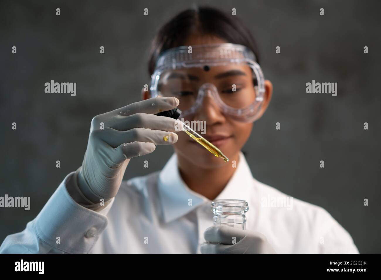 Chemical research scientist working in the lab with colorful liquids ...