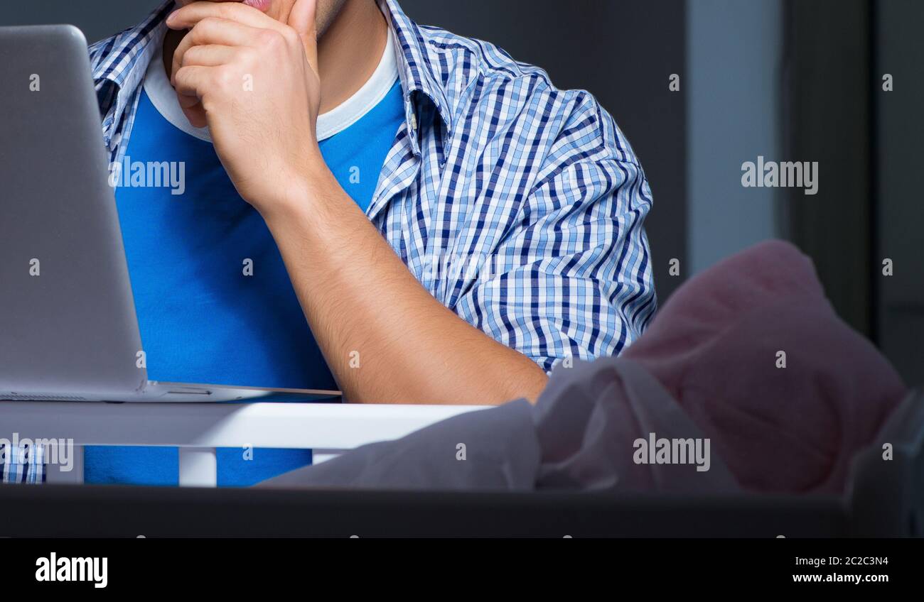 Young student doing homework and looking after newborn baby Stock Photo ...