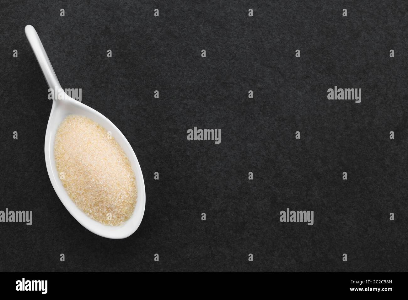 Yellow instant jelly or jello powder on small spoon, photographed ...