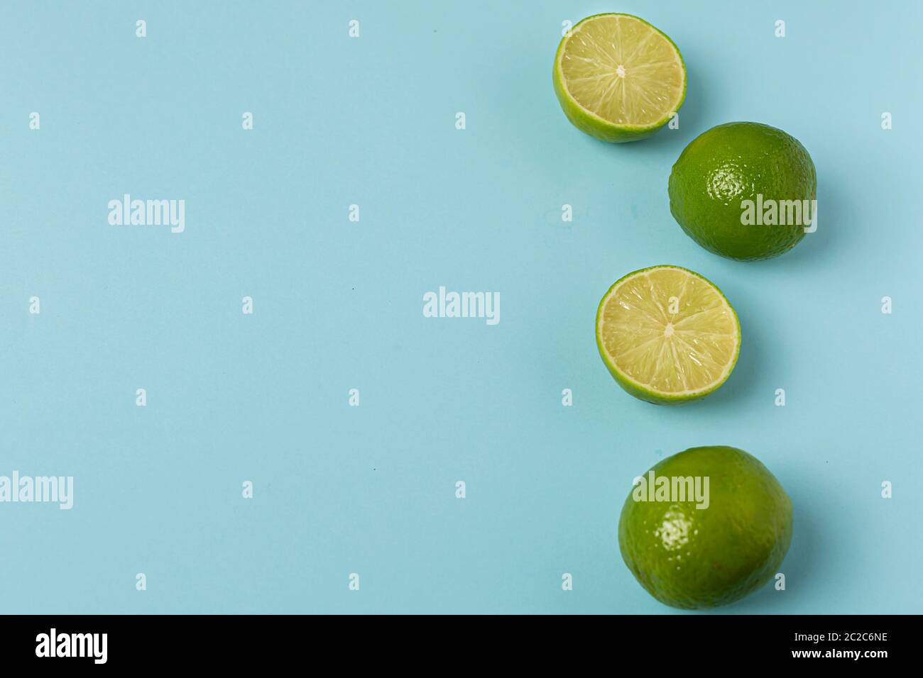 Fresh Limes over a light blue background with large copy space. Minimal ...