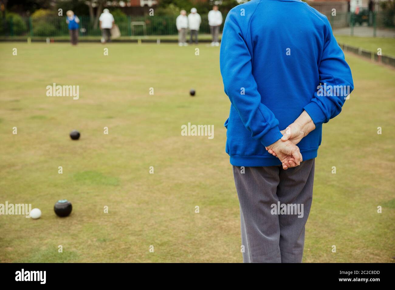 A rear view shot of an unrecognizable person spectating a lawn bowling ...