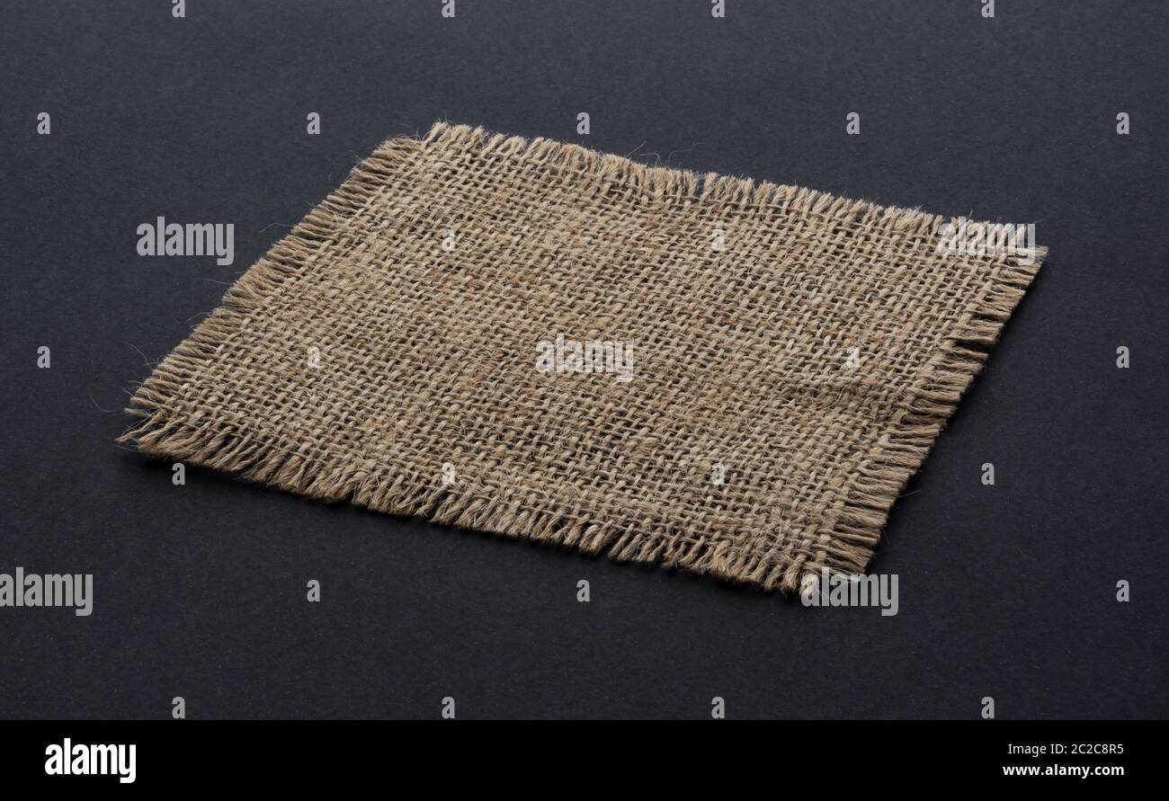Old burlap fabric napkin on black background Stock Photo - Alamy