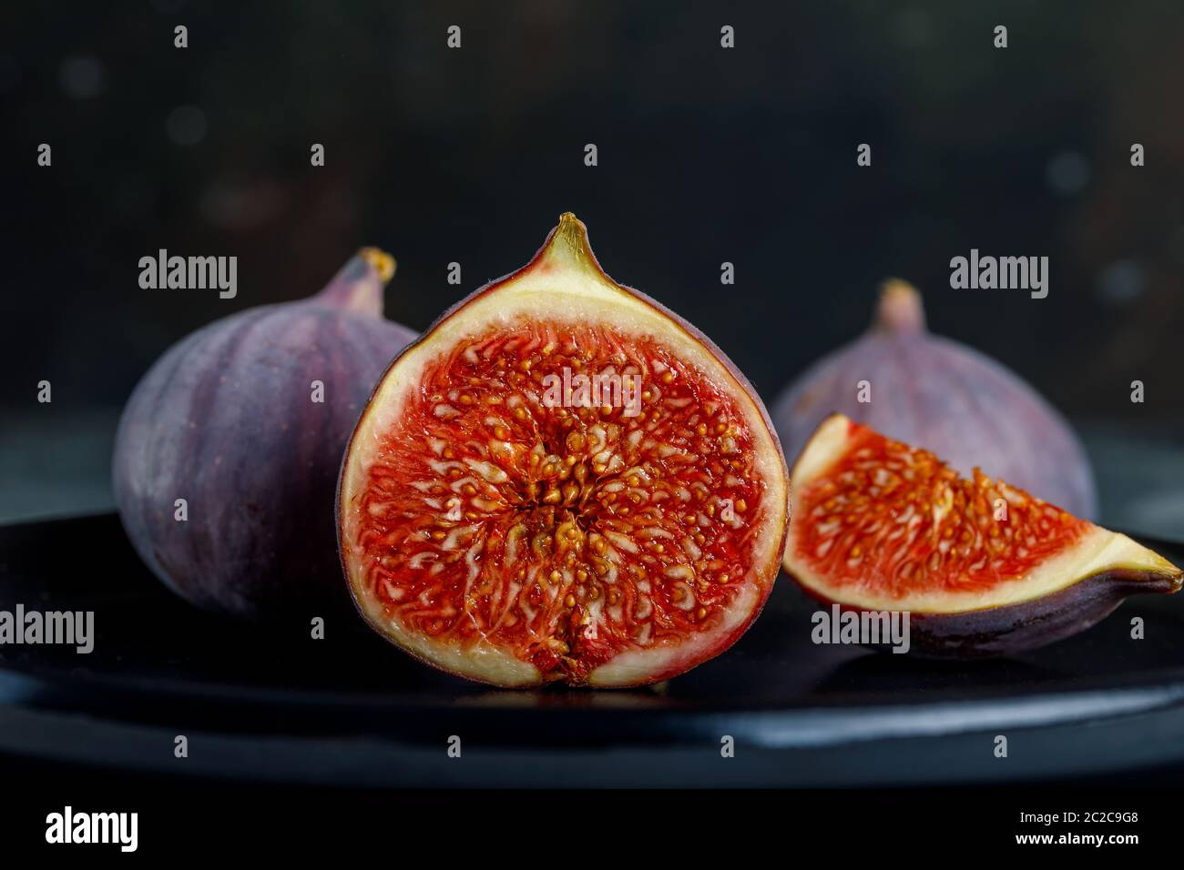 Tropical fig fruit, fresh in half section on the background of whole ...