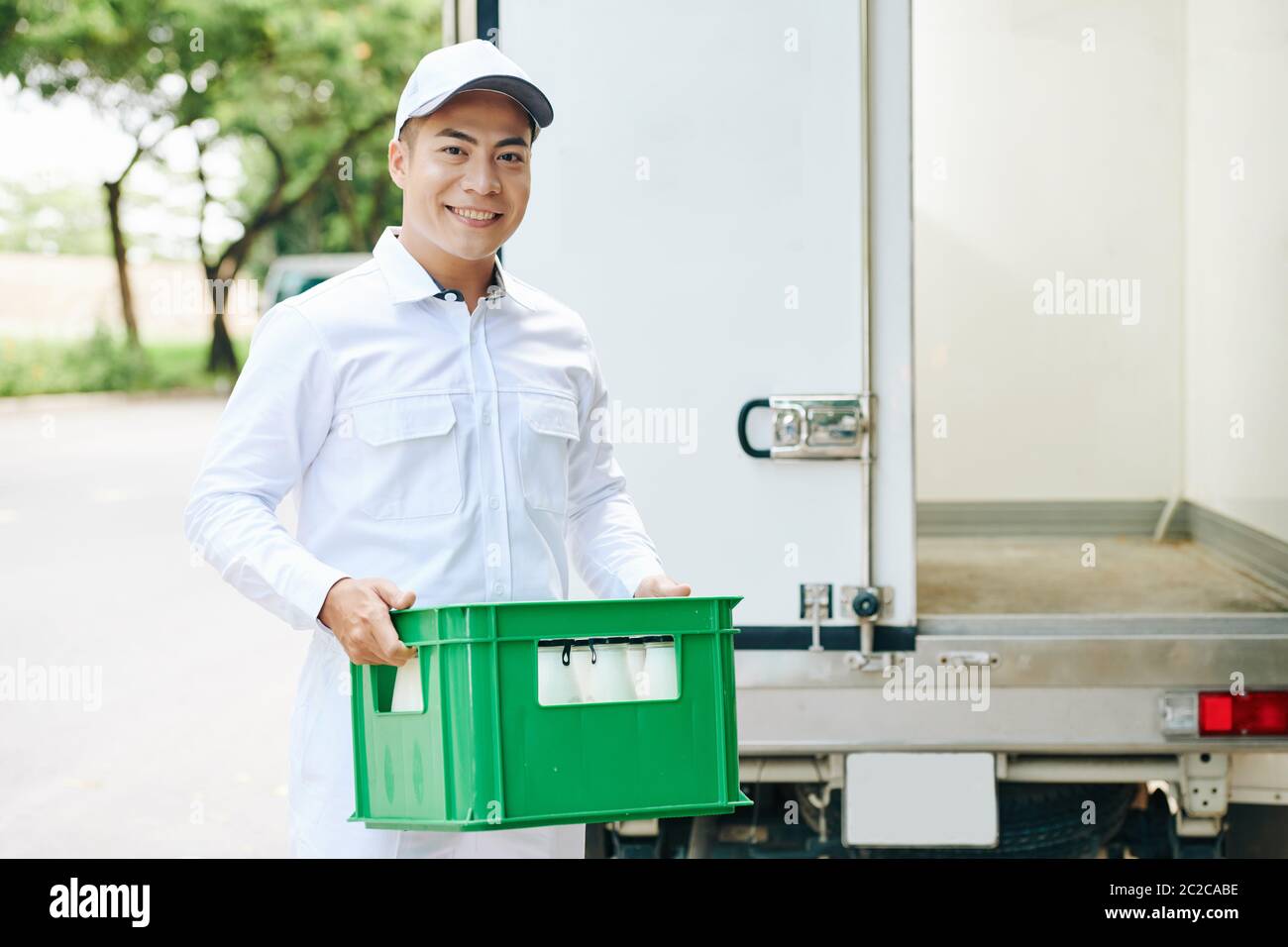 Horizontal medium portrait of modern milkman wearing white clothes ...