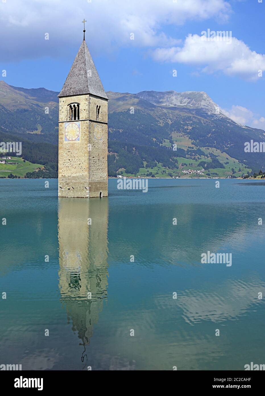 The church tower of Graun with reflection in the Reschensee Stock Photo ...