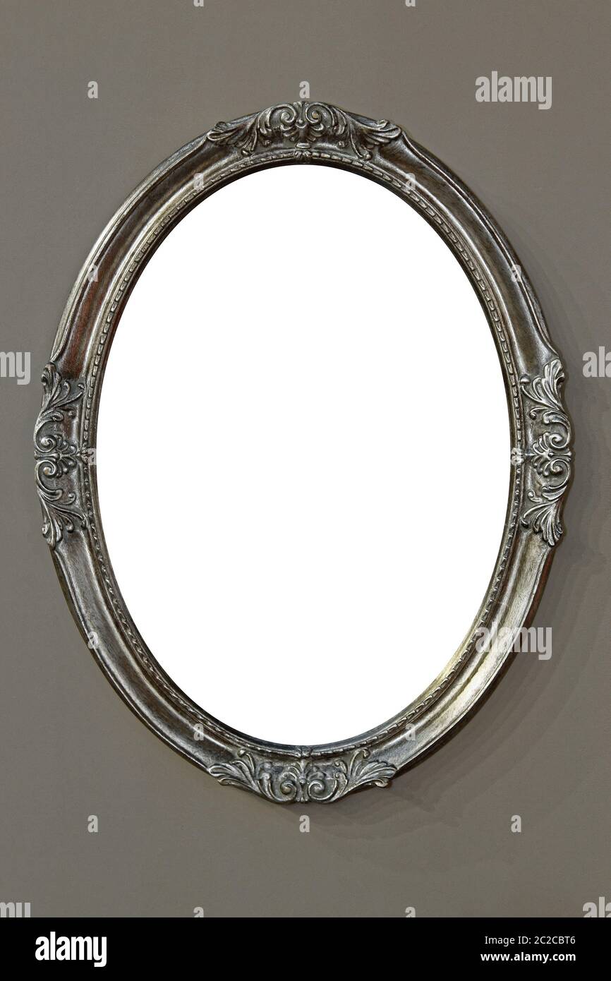 Decorative Oval Mirror Frame Hanging on Wall Stock Photo - Alamy