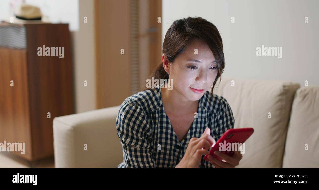 Woman use of mobile phone at home in the evening Stock Photo - Alamy
