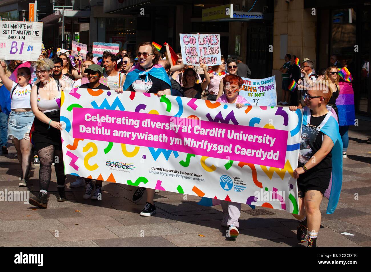 Cardiff University bilingual banner and marchers at the 2019 Gay Pride ...