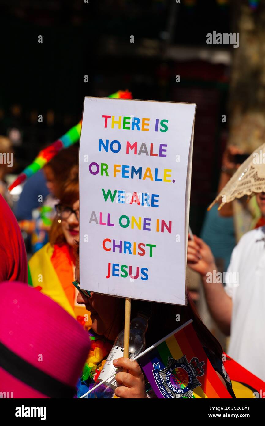 Person holding up a placard about being Christian and being gay/trans ...