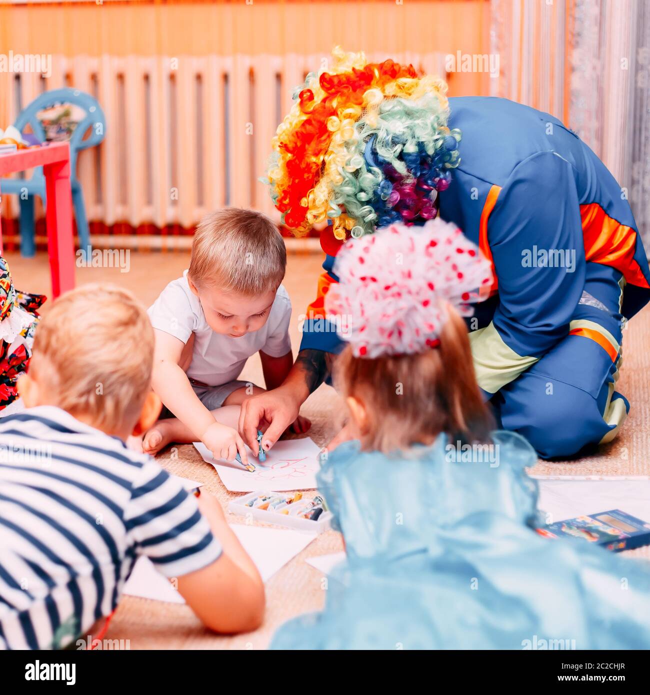 children paint drow paper on floor with clown Stock Photo - Alamy