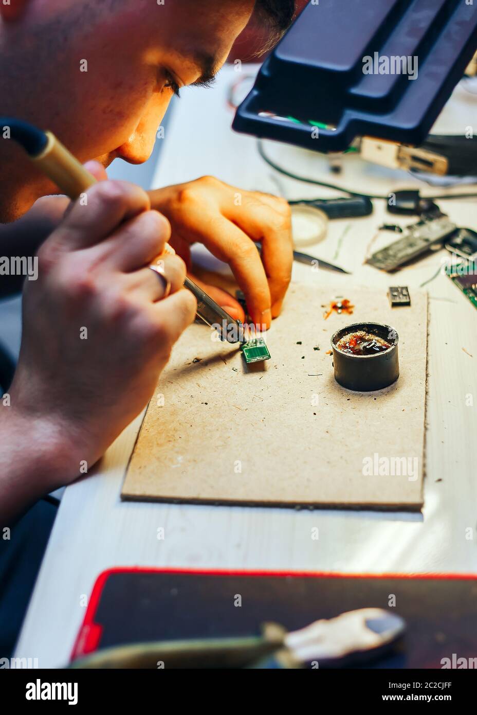 Image of engineer with soldering iron repairing mechanism Stock Photo ...