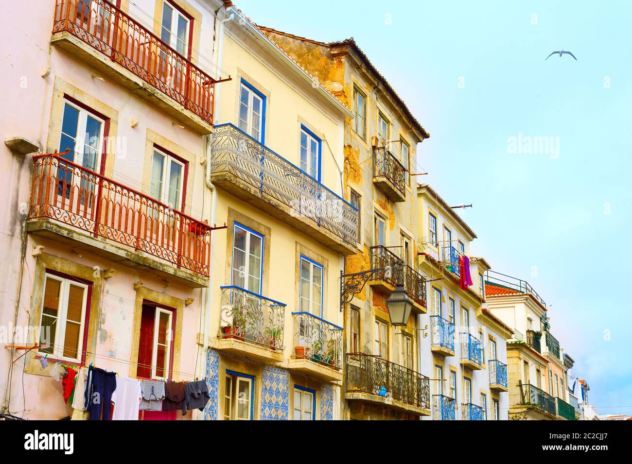 Typical portugese street with traditional tiled architecture and drying ...