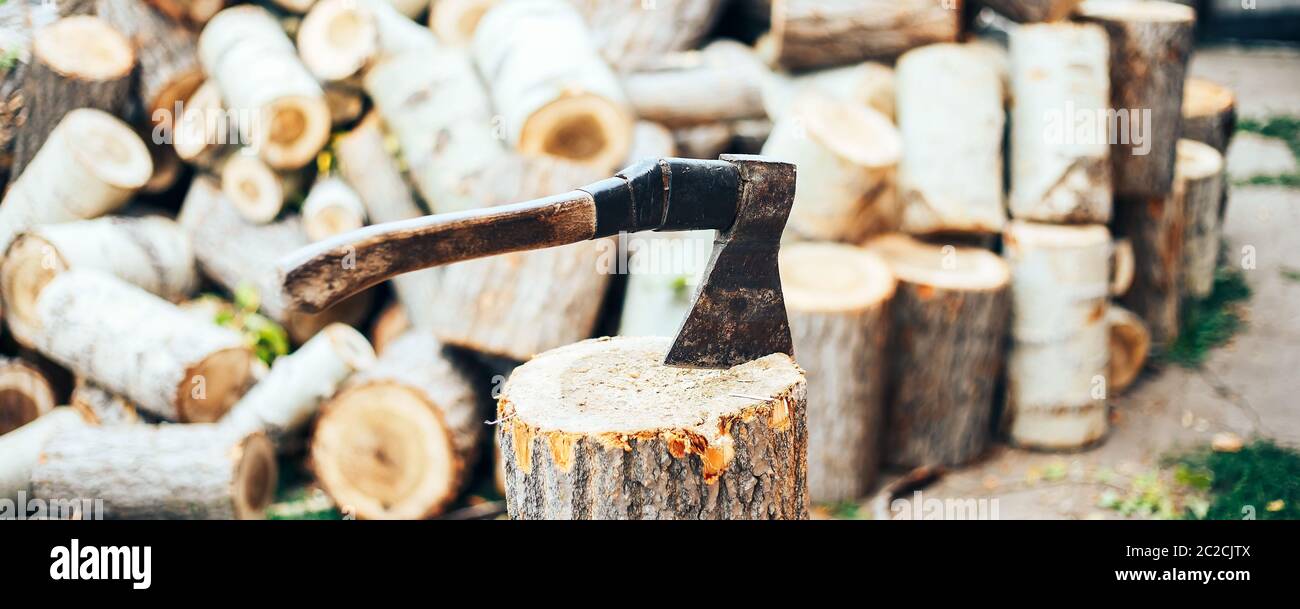 A sharp blade of an ax that sticks out in a wooden chock. rustic ...