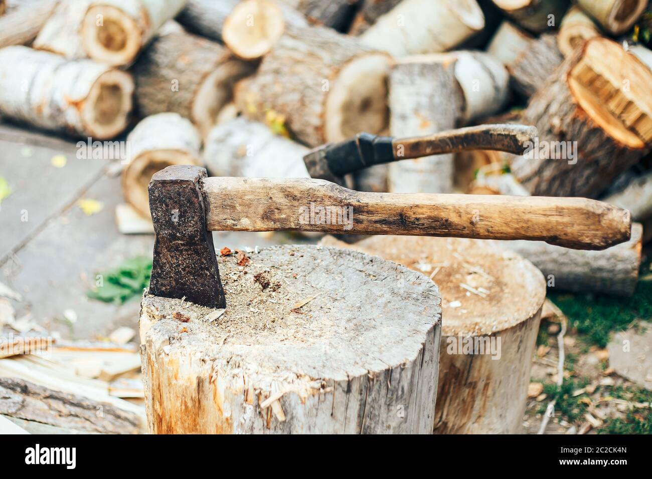 A sharp blade of an ax that sticks out in a wooden chock. rustic ...