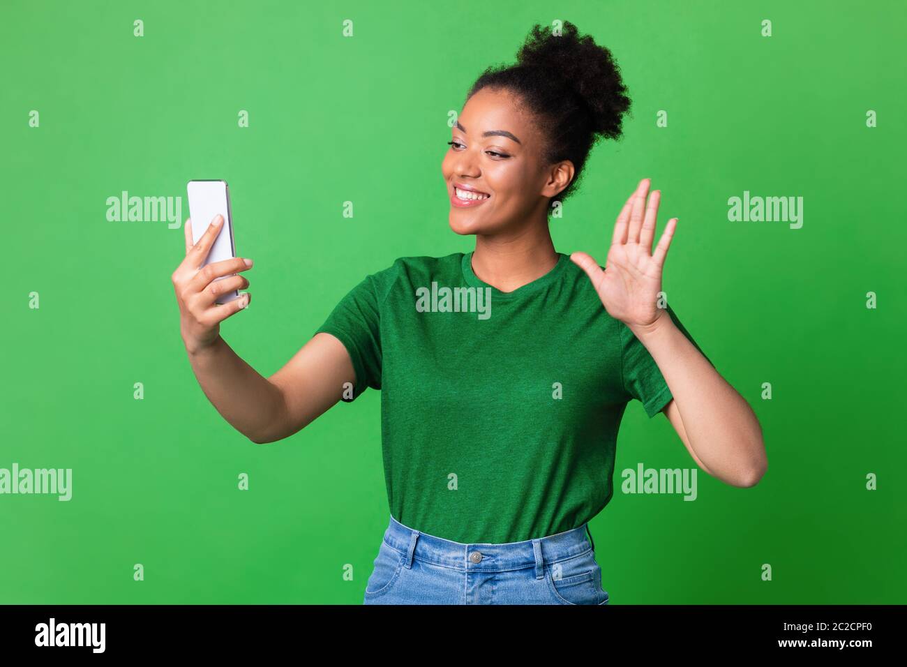 Happy girl using mobile phone at studio Stock Photo - Alamy