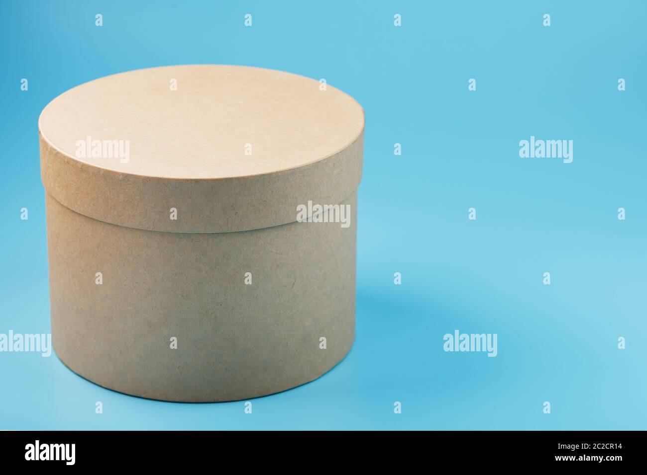 Round cardboard box on a blue background, free space Stock Photo - Alamy