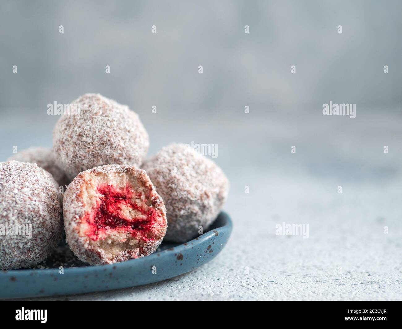 Raw lamington bliss balls with raspberries chia jam Stock Photo - Alamy