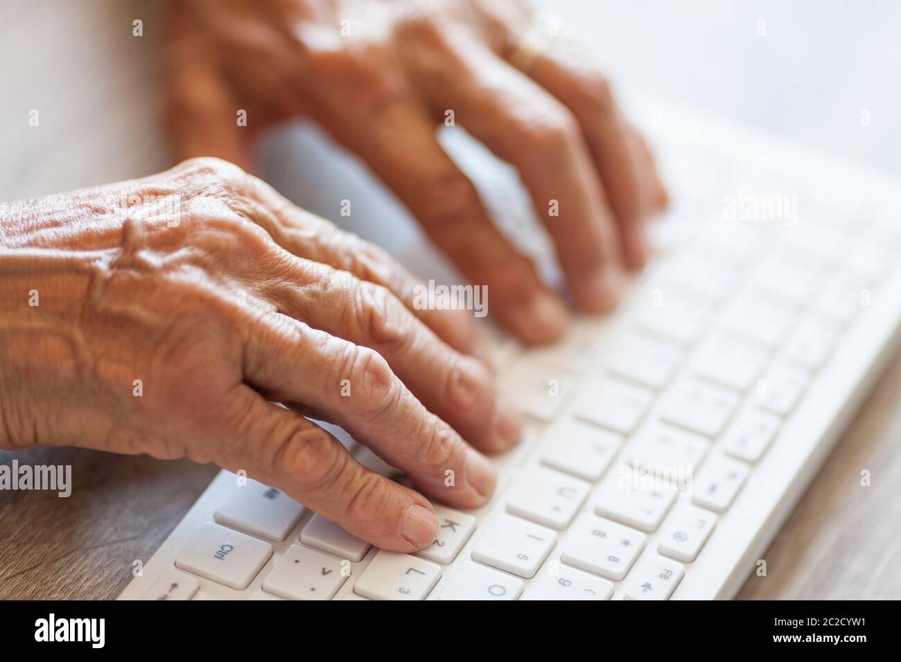 Elderly woman typing on a PC keyboard Stock Photo - Alamy