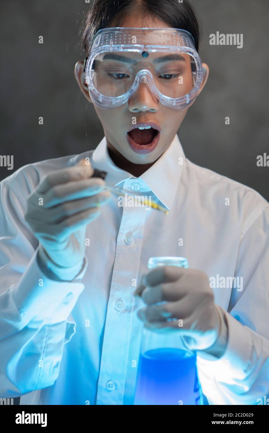Chemical research scientist working in the lab with colorful liquids ...