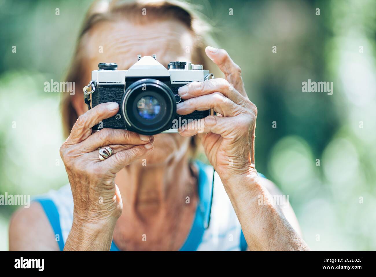 Elderly woman with a vintage film photo camera Stock Photo - Alamy