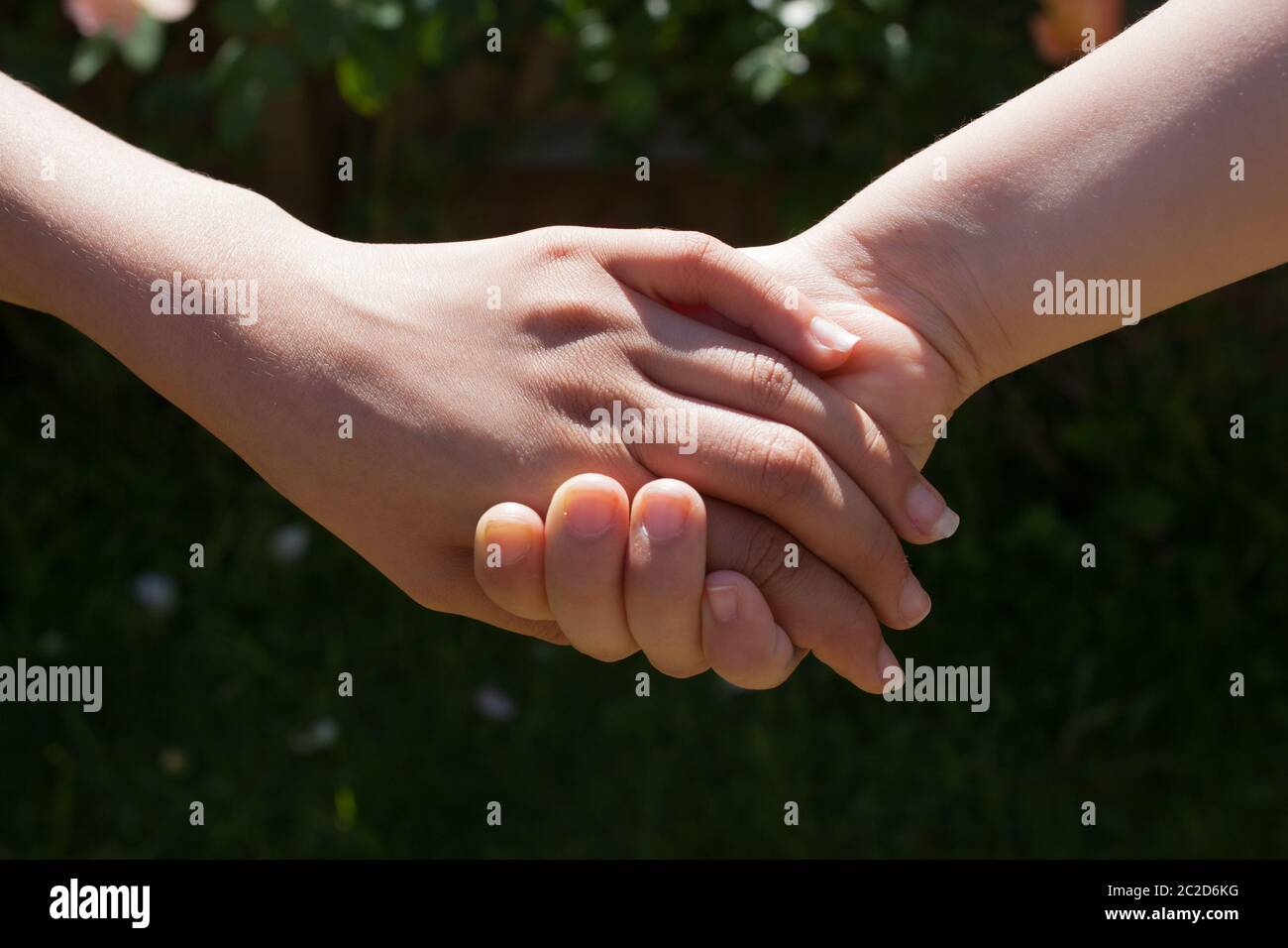 Two girls hands held together offering closeness and friendship Stock ...