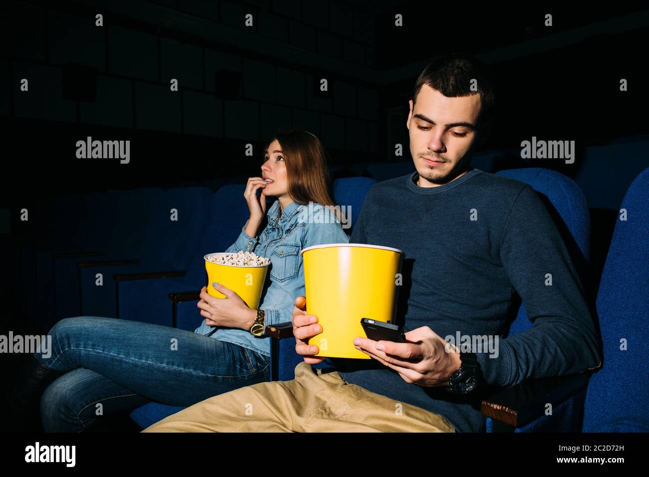 Smart phone in cinema. Man using smartphone while watching movie at the ...