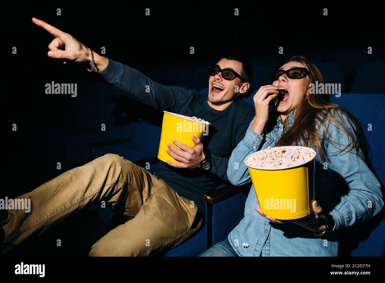 Cinema day, young couple with popcorn looking action movie in cinema ...