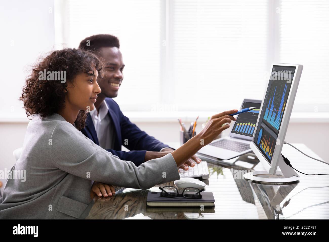 Stock Market Broker Analyzing Graphs On Computer In Office Stock Photo ...