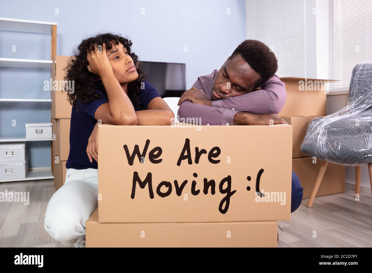 Stressed Couple Sitting Near Boxes In New Home Stock Photo - Alamy