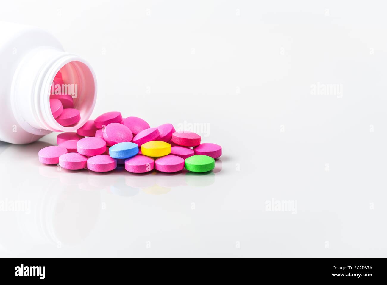 Multicolored pills are scattered from a jar on a white background Stock ...