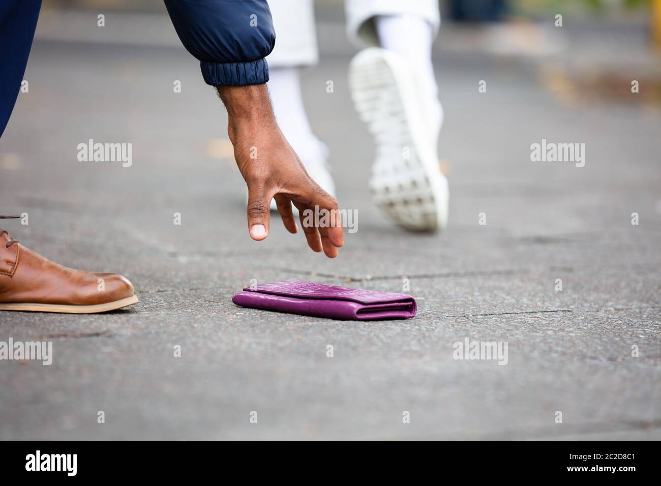Person Picking Up Lost Purse On Street Stock Photo - Alamy