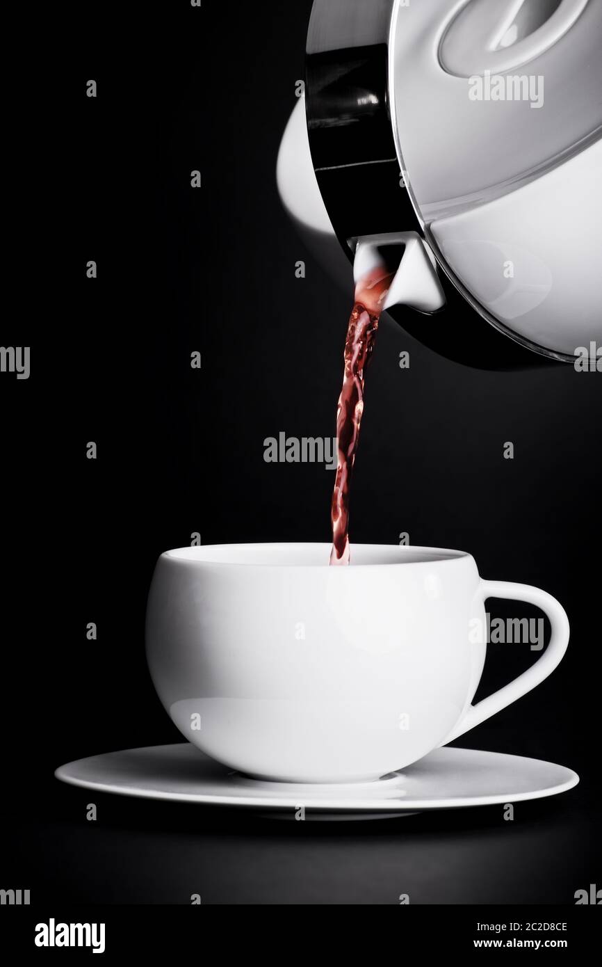 Pouring tea on black background. Low key photograph of a tea pouring in ...
