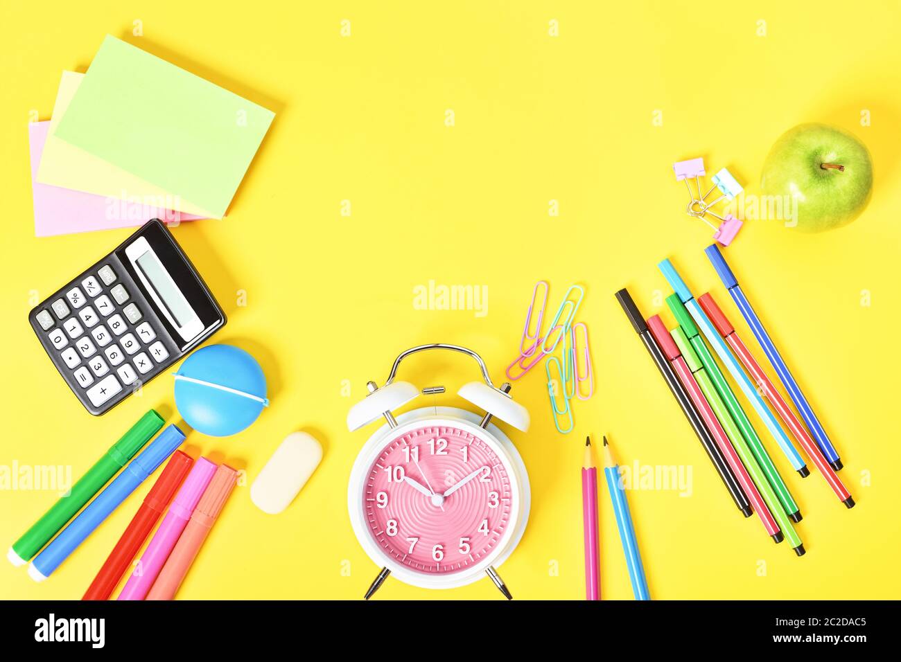 Fun school stationary scattered at the bottom on yellow background ...