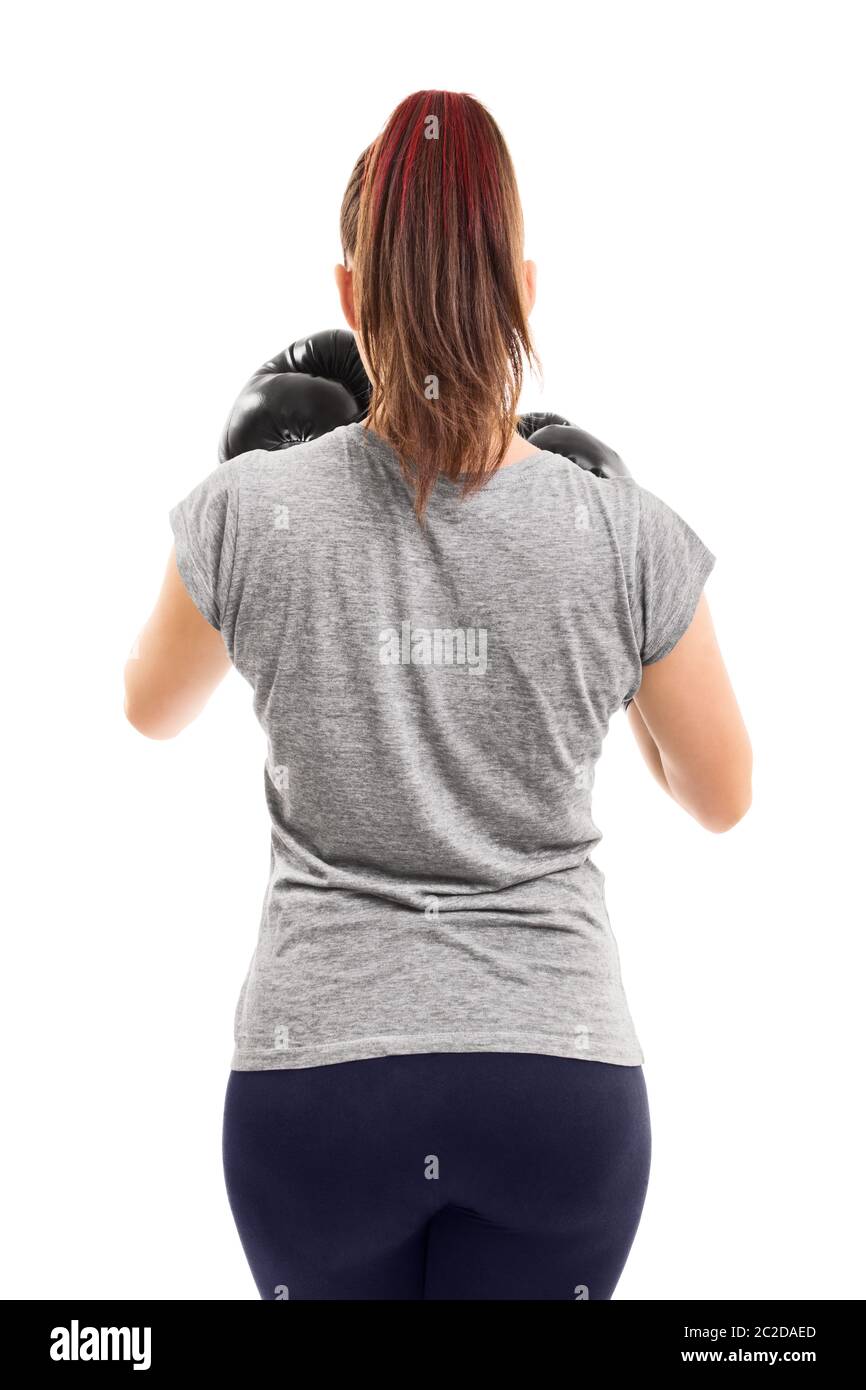 Muscular female boxer with her guard up, photographed from behind ...