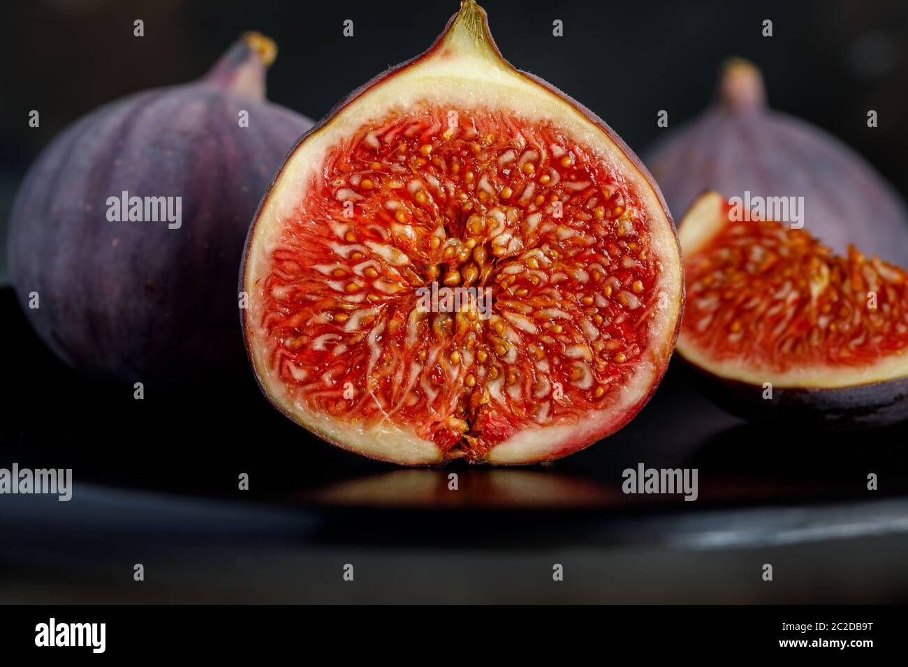 Tropical fig fruit, fresh in half section on the background of whole ...