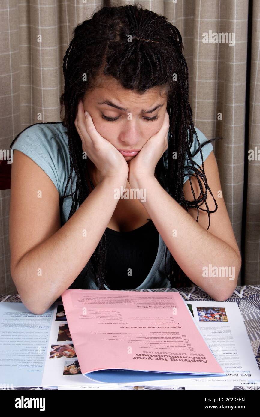 Worried student reading application forms for university accommodation ...