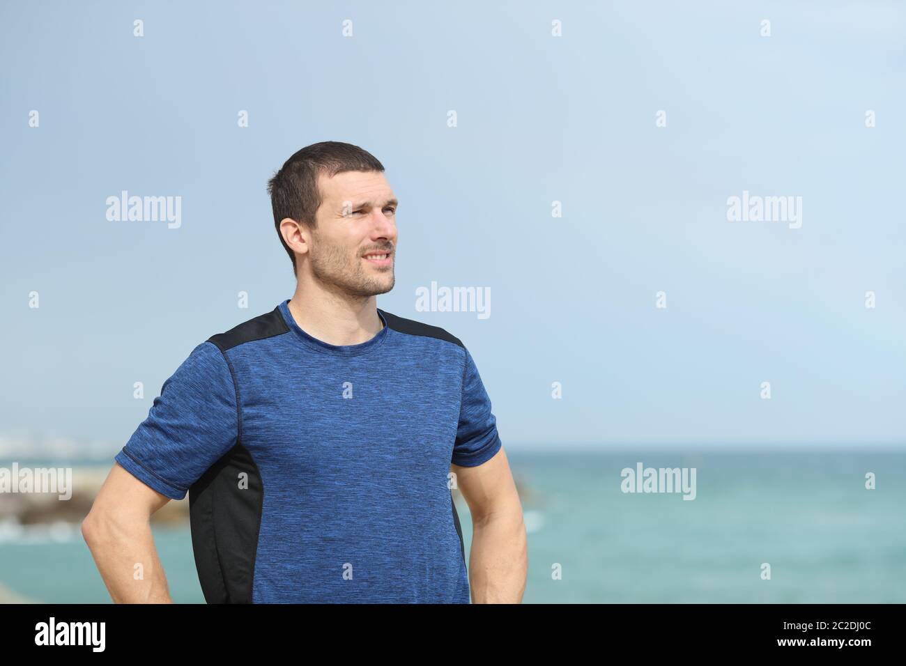 Handsome runner looking away on the beach Stock Photo - Alamy