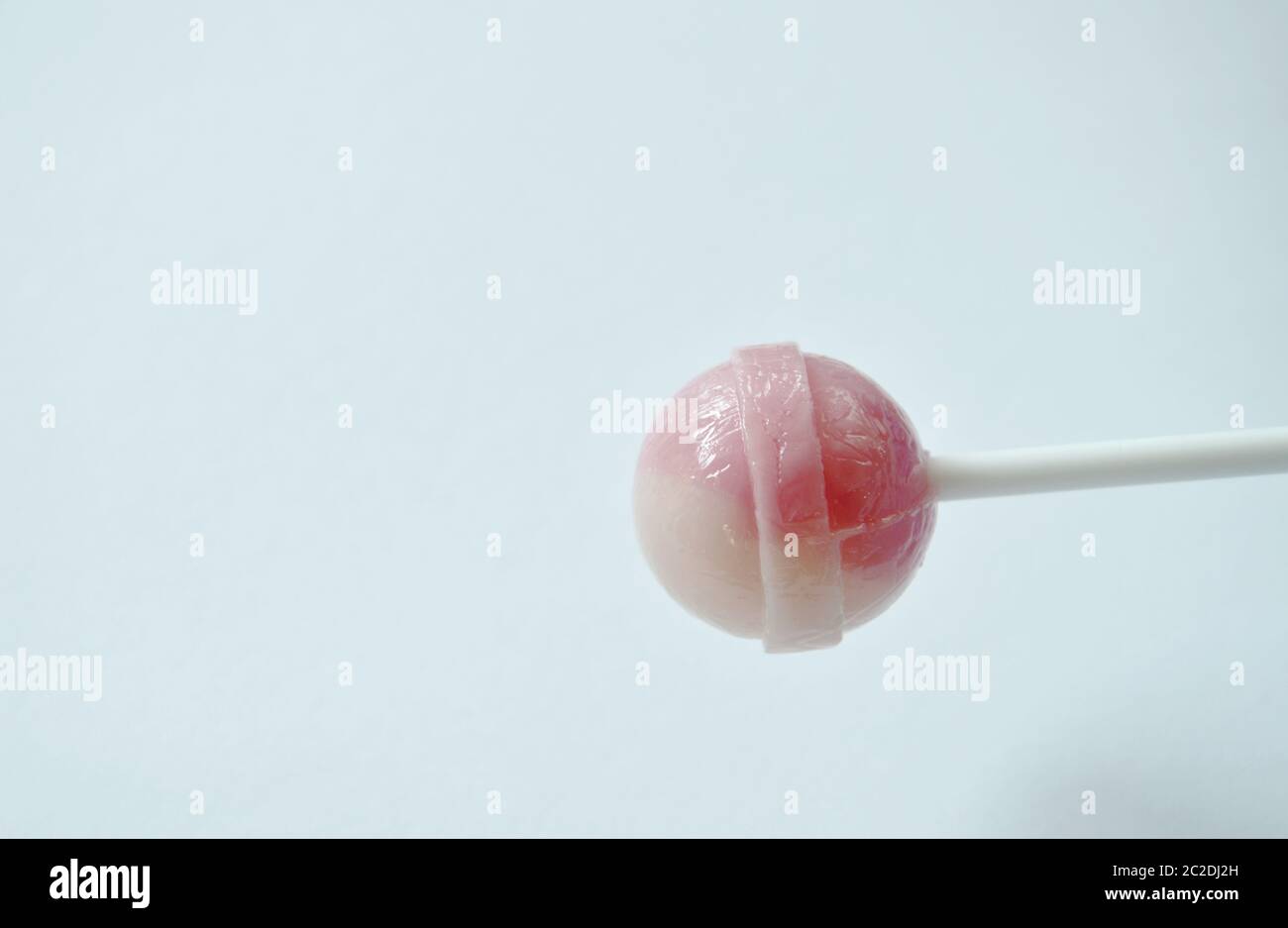 lollipop candy with white plastic stick burning to melt on white ...