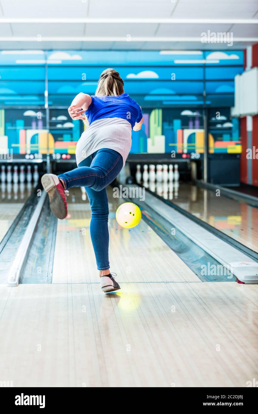Rear view of a young woman bowling Stock Photo - Alamy