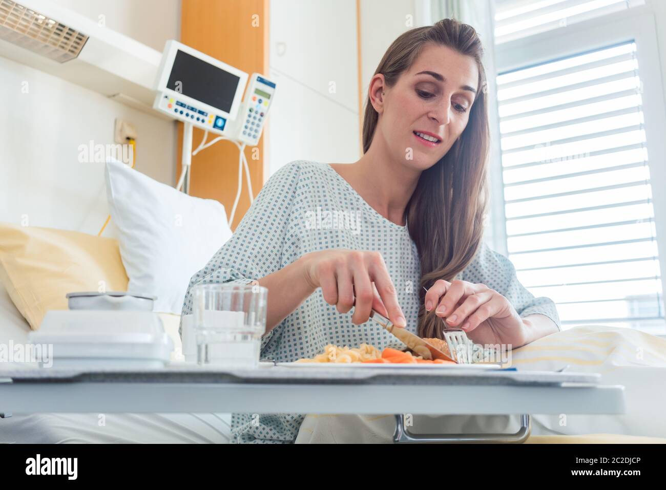 Patient in hospital lying in bed eating meal enjoying the food Stock ...