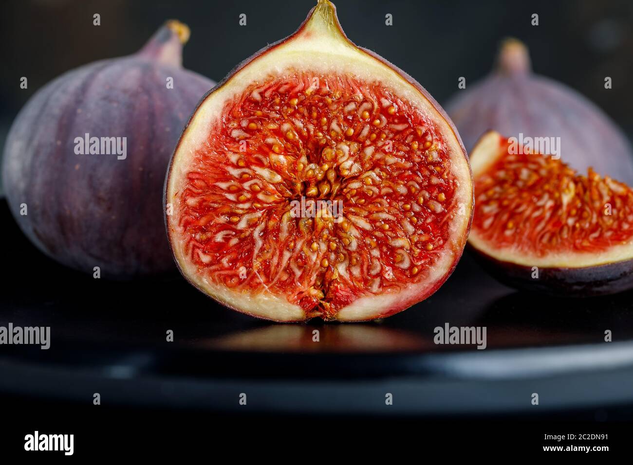 Tropical fig fruit, fresh in half section on the background of whole ...