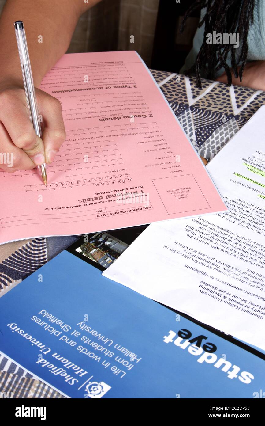 Person's hand filling out forms to apply for place at university Stock ...