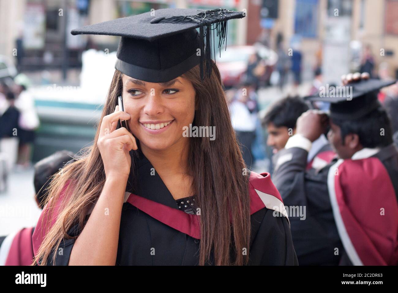 university graduate on mobile phone, graduation day in the city Stock ...