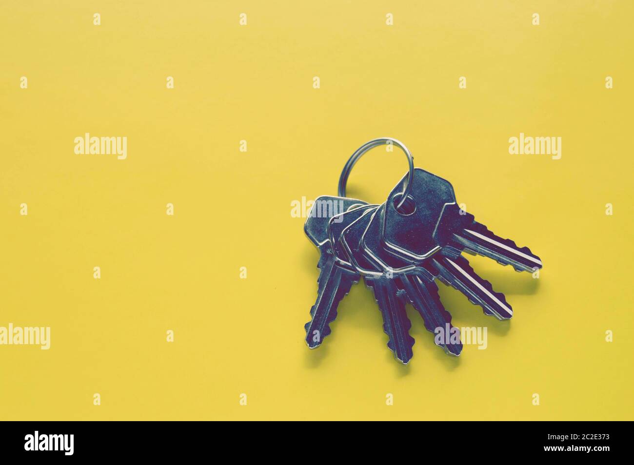 Bunch of silver keys on a yellow background Stock Photo - Alamy